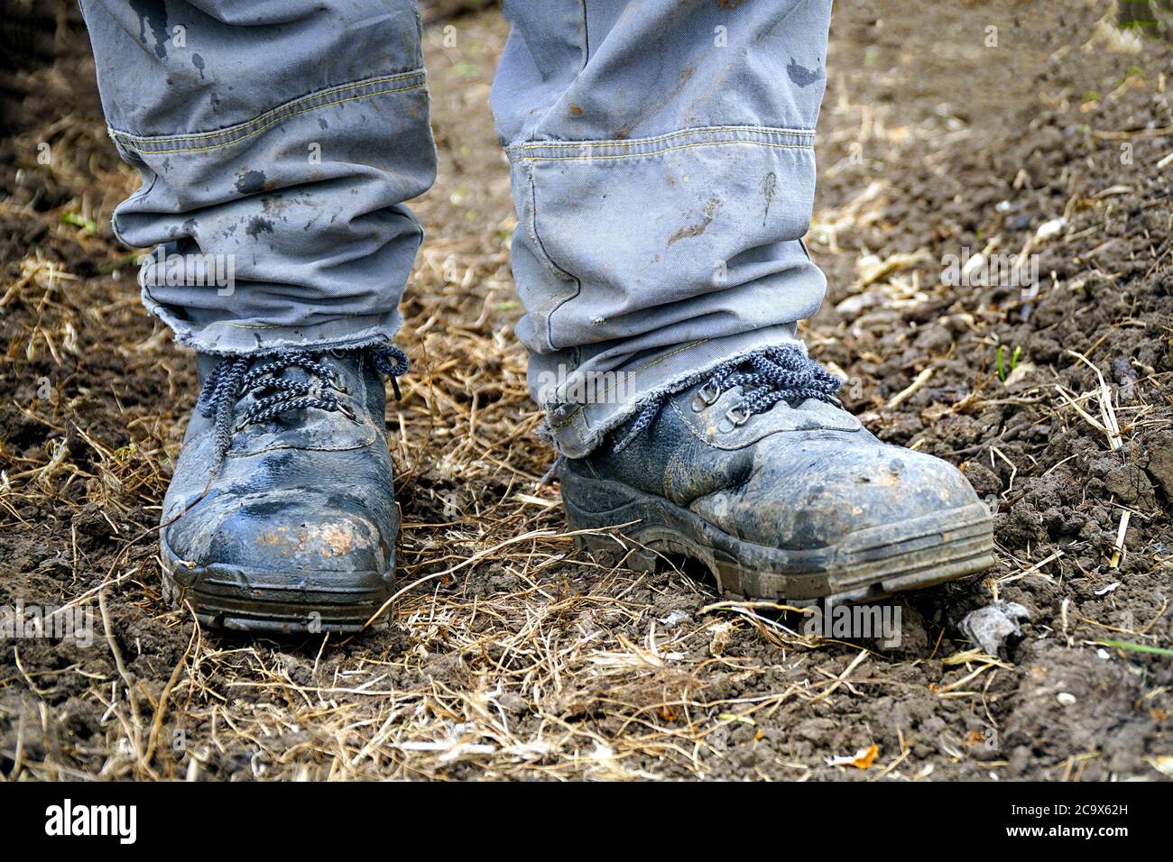 Worker's feet in dusty boots. A man in overalls and work boots. Work ...