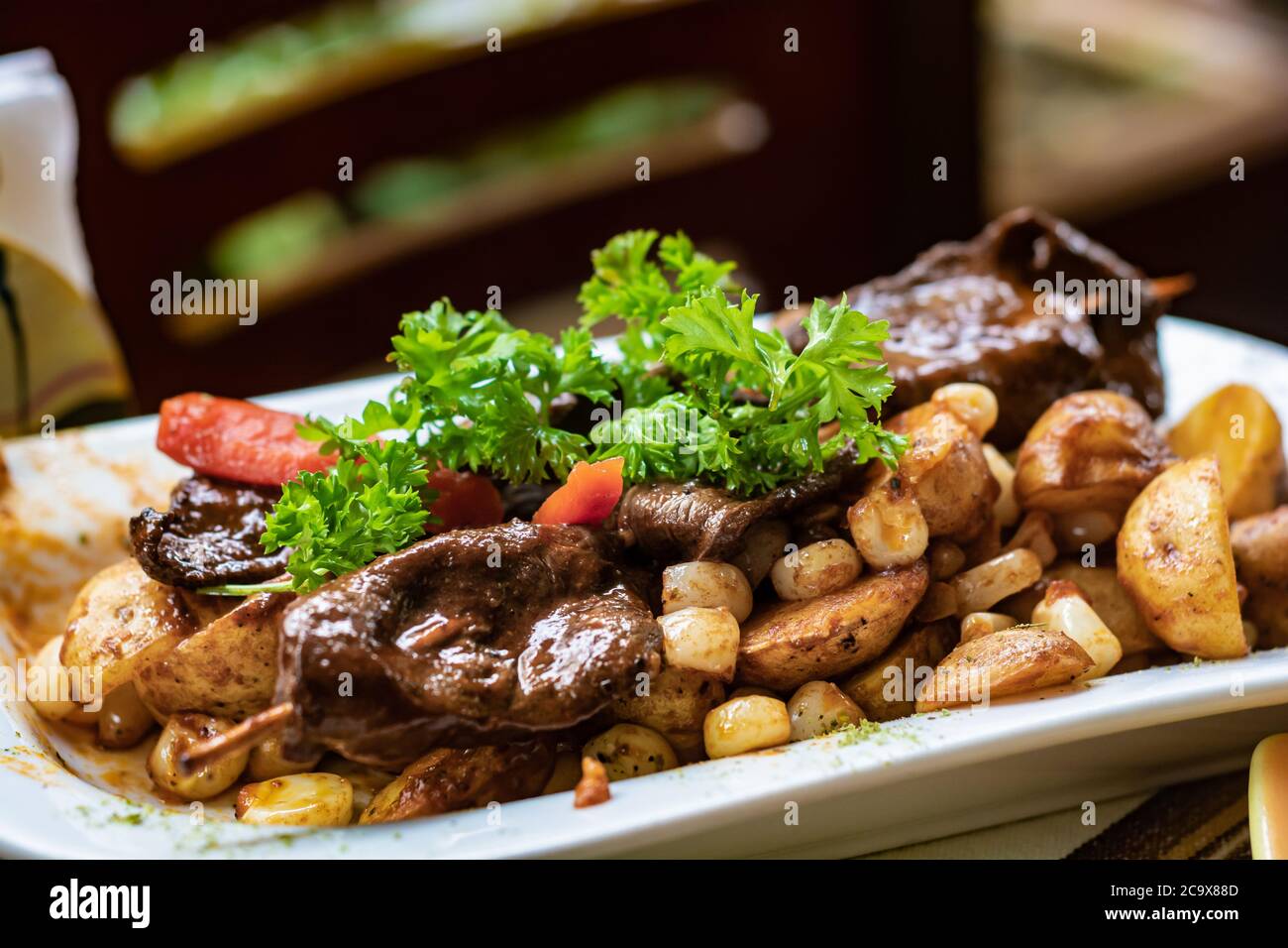 Typical andean food called "anticucho" made with beef heart and served ...