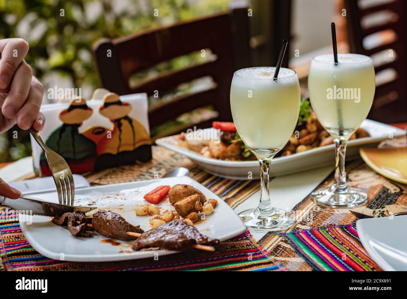 A person eats a typical Peruvian food anticuchos served with the ...