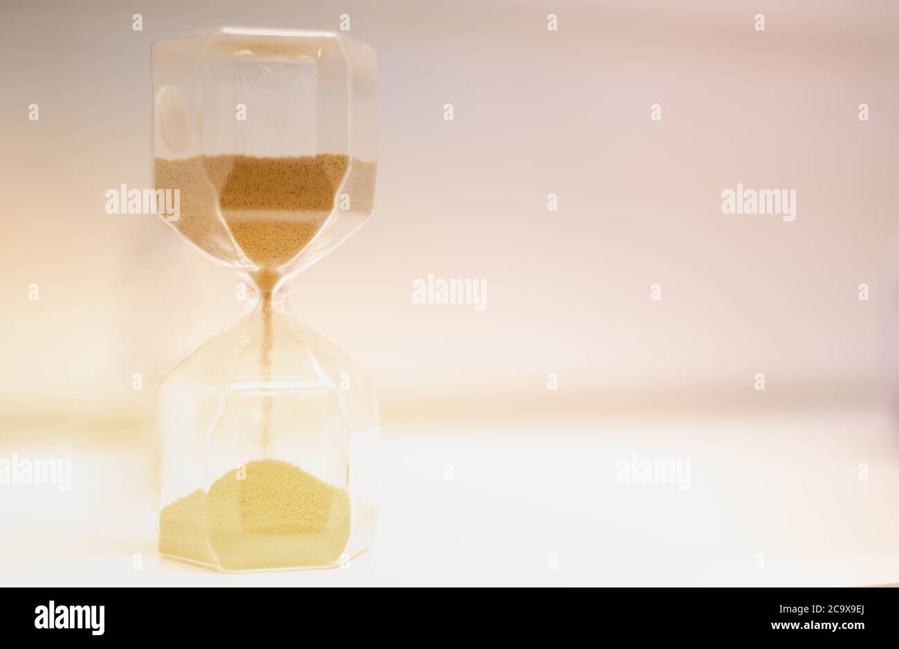 Sand running through the hourglass measuring the passing time in a ...