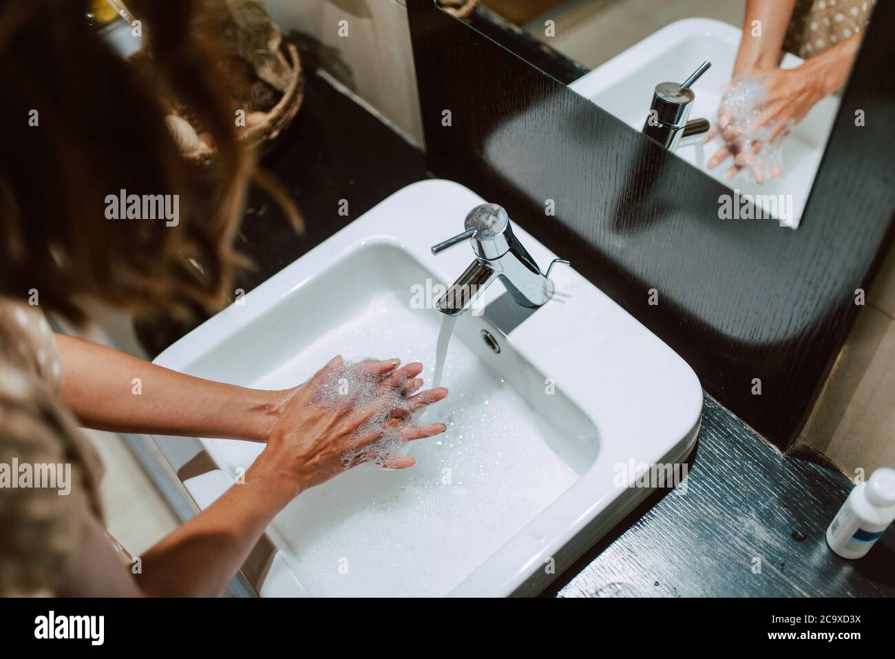Top view of woman hands while washing hands with soap in the bathroom ...