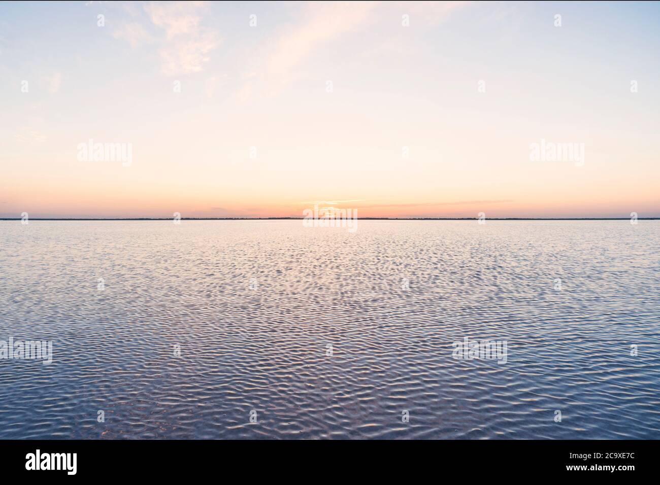 sun sets ha horizon on pink and violet the sky. Pink lake. Striking red ...