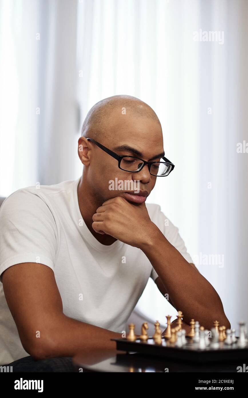 Portrait of pensive bald Black man thinking about next movement in ...