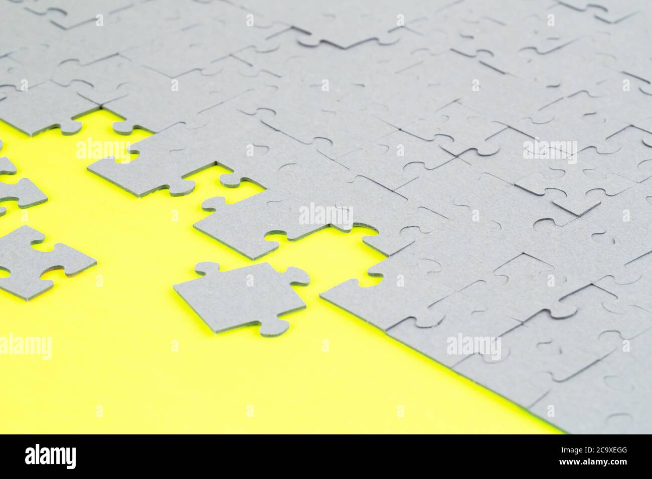 Unfinished jigsaw puzzle pieces on yellow background Stock Photo - Alamy
