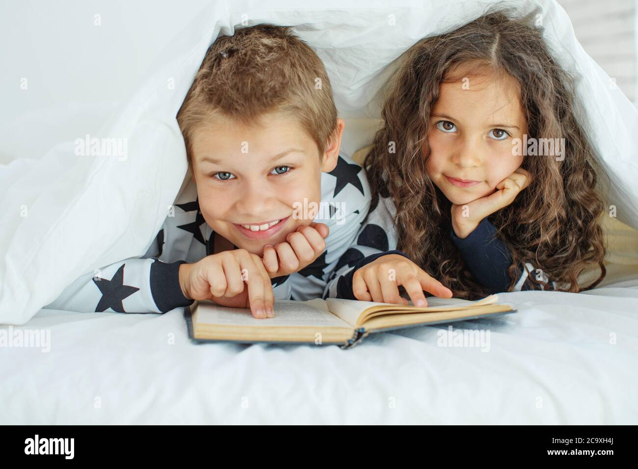 Children are reading a book Stock Photo - Alamy
