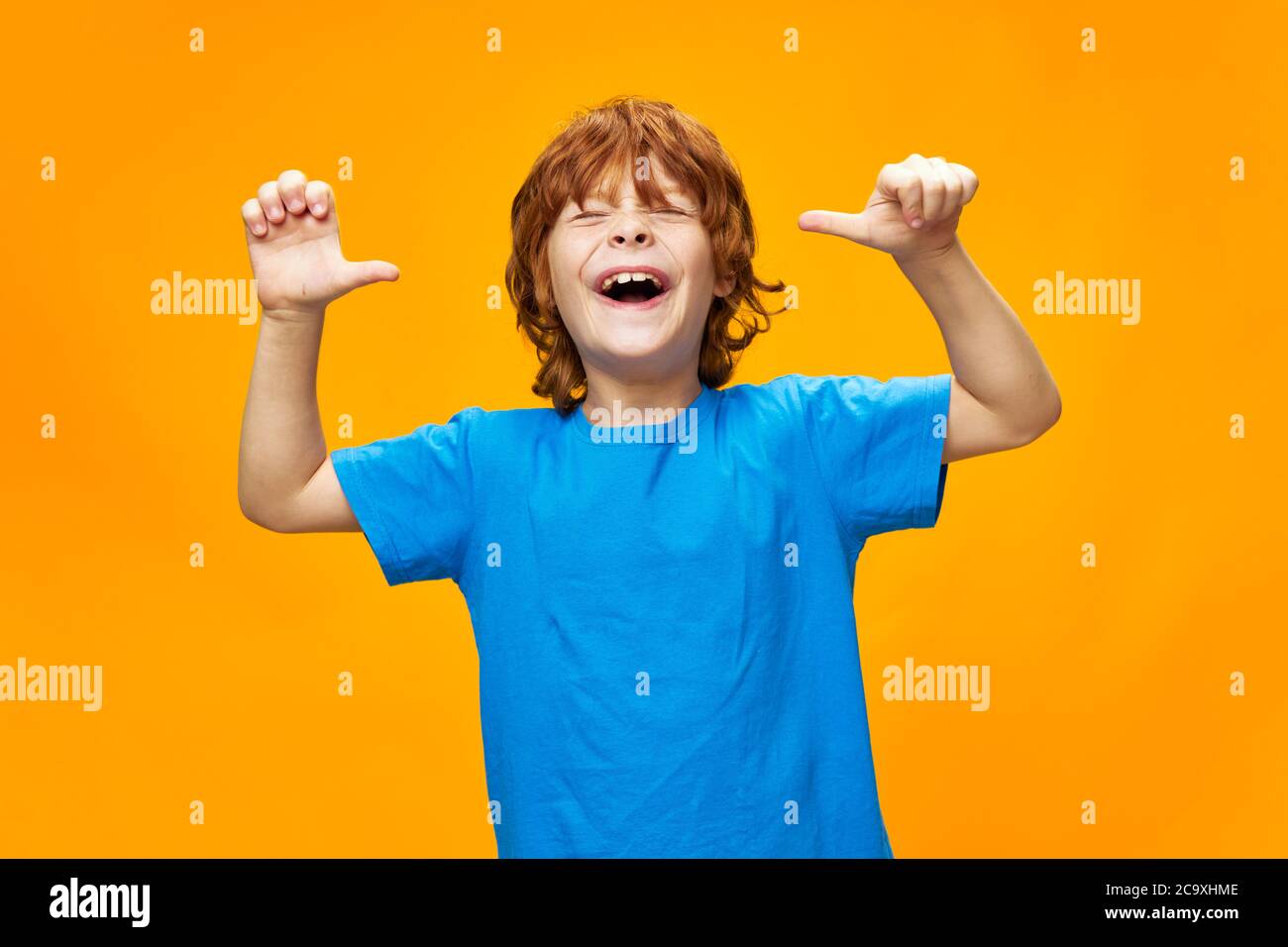 red hair blue t-shirt yellow background happy child Stock Photo - Alamy