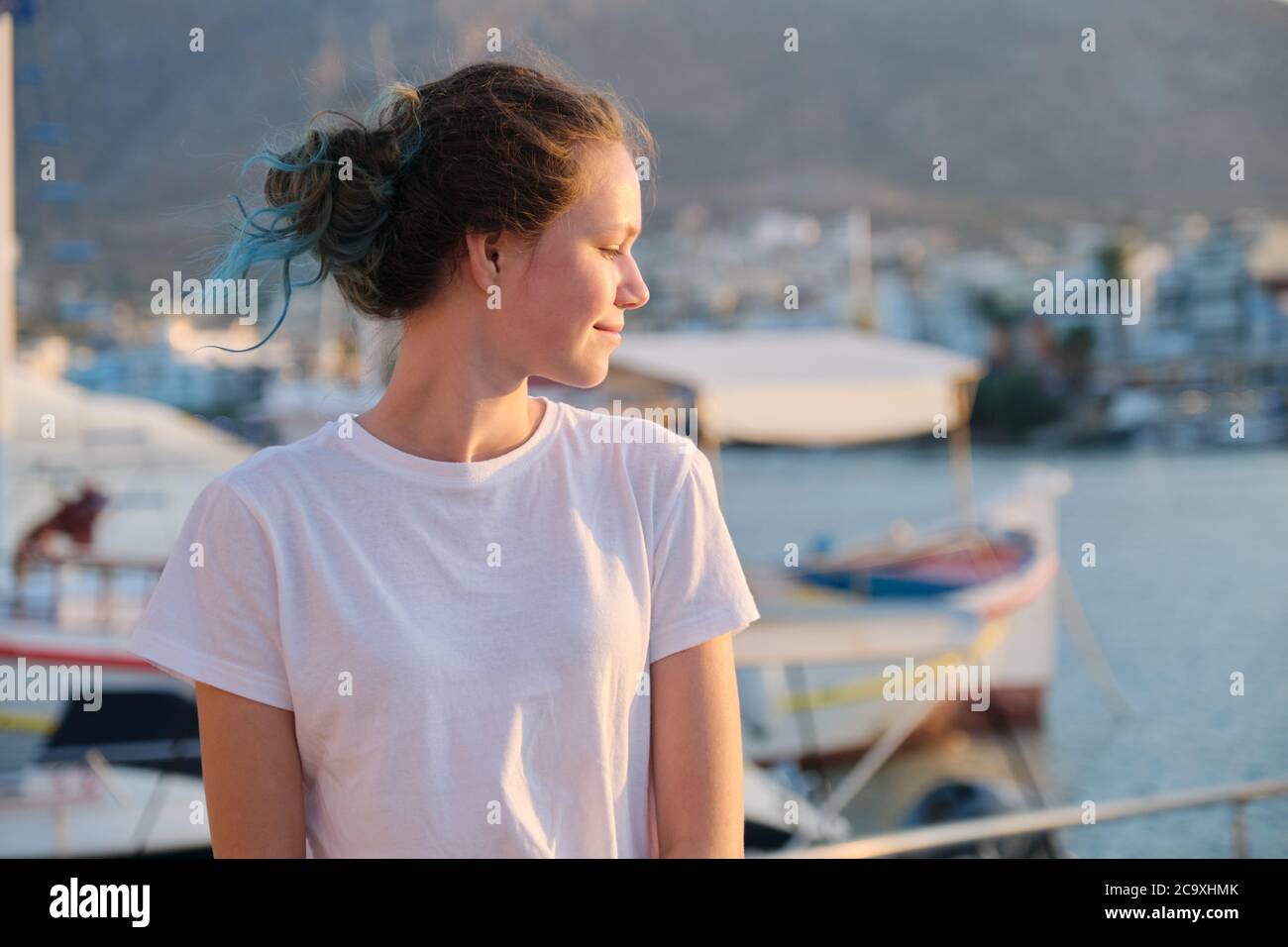 Portrait of beautiful smiling teenager girl in profile looking to the ...