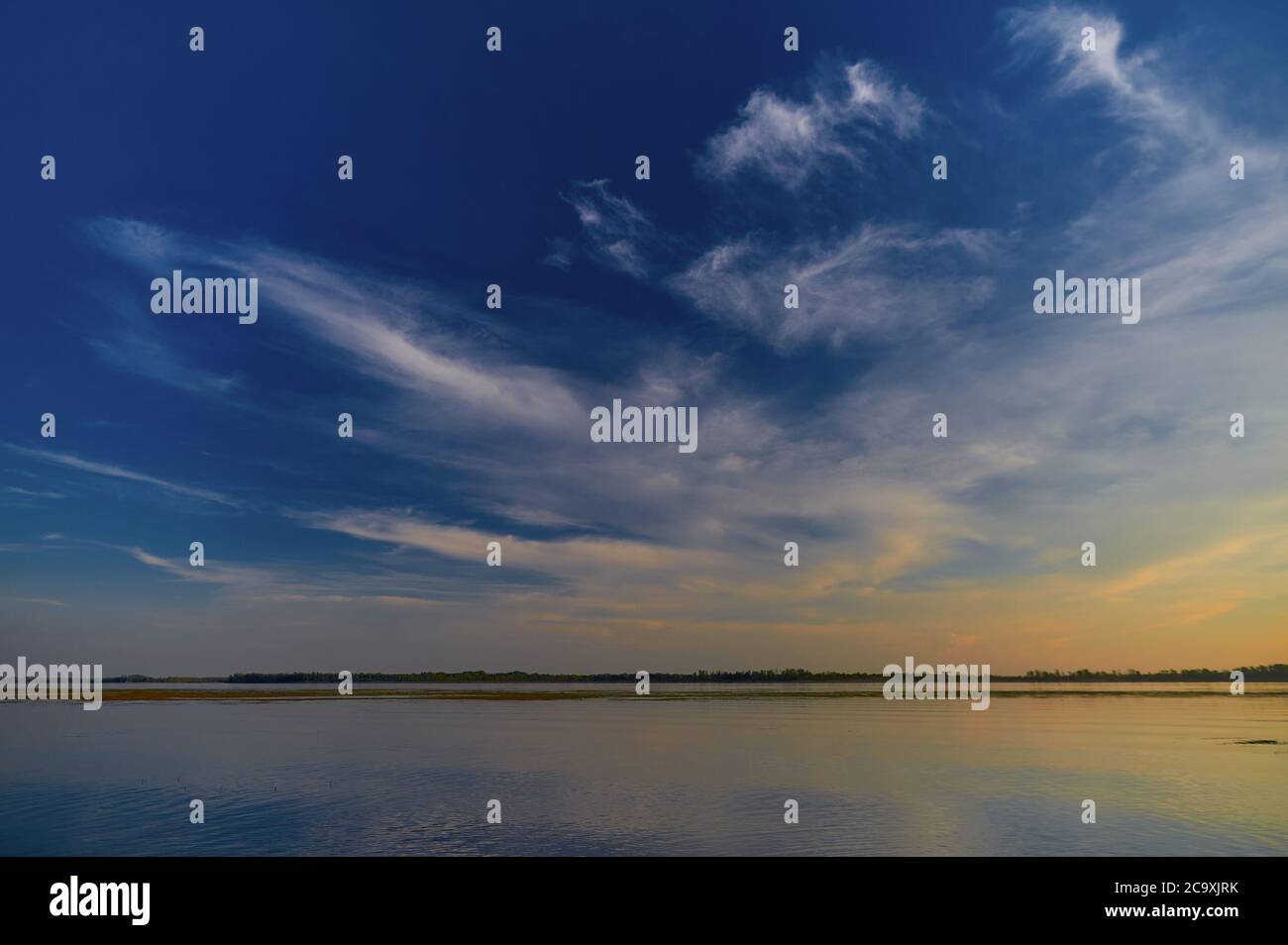 A sunset over a body of water Stock Photo - Alamy