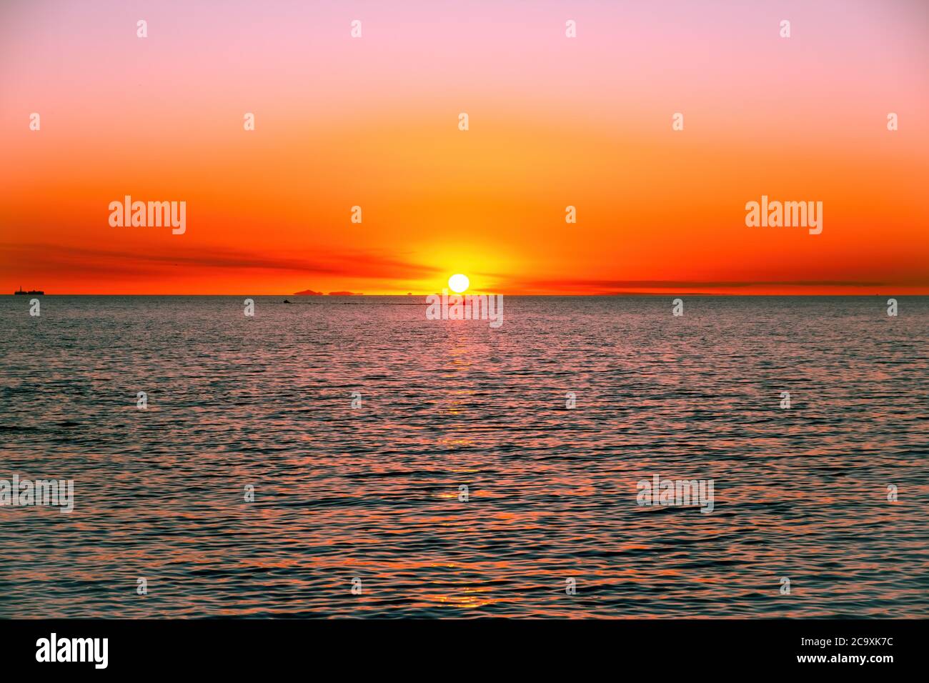 Vivid red glowing sunset over sea with small fishing boat - minimalist ...