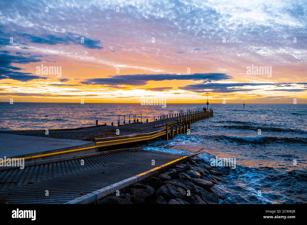 Beautiful glowing sunset over ocean and small boat jetty in Melbourne ...
