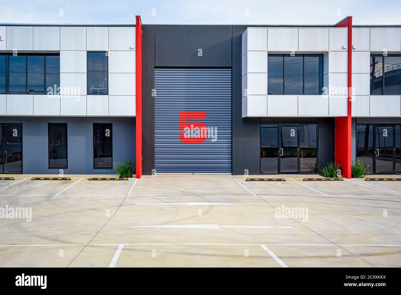 Industrial building with empty parking lot. Closed warehouse door with ...