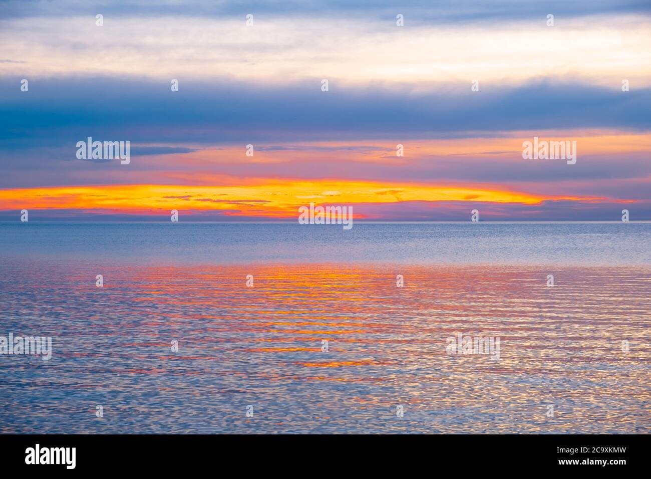 Colorful sunset over ocean water Stock Photo - Alamy