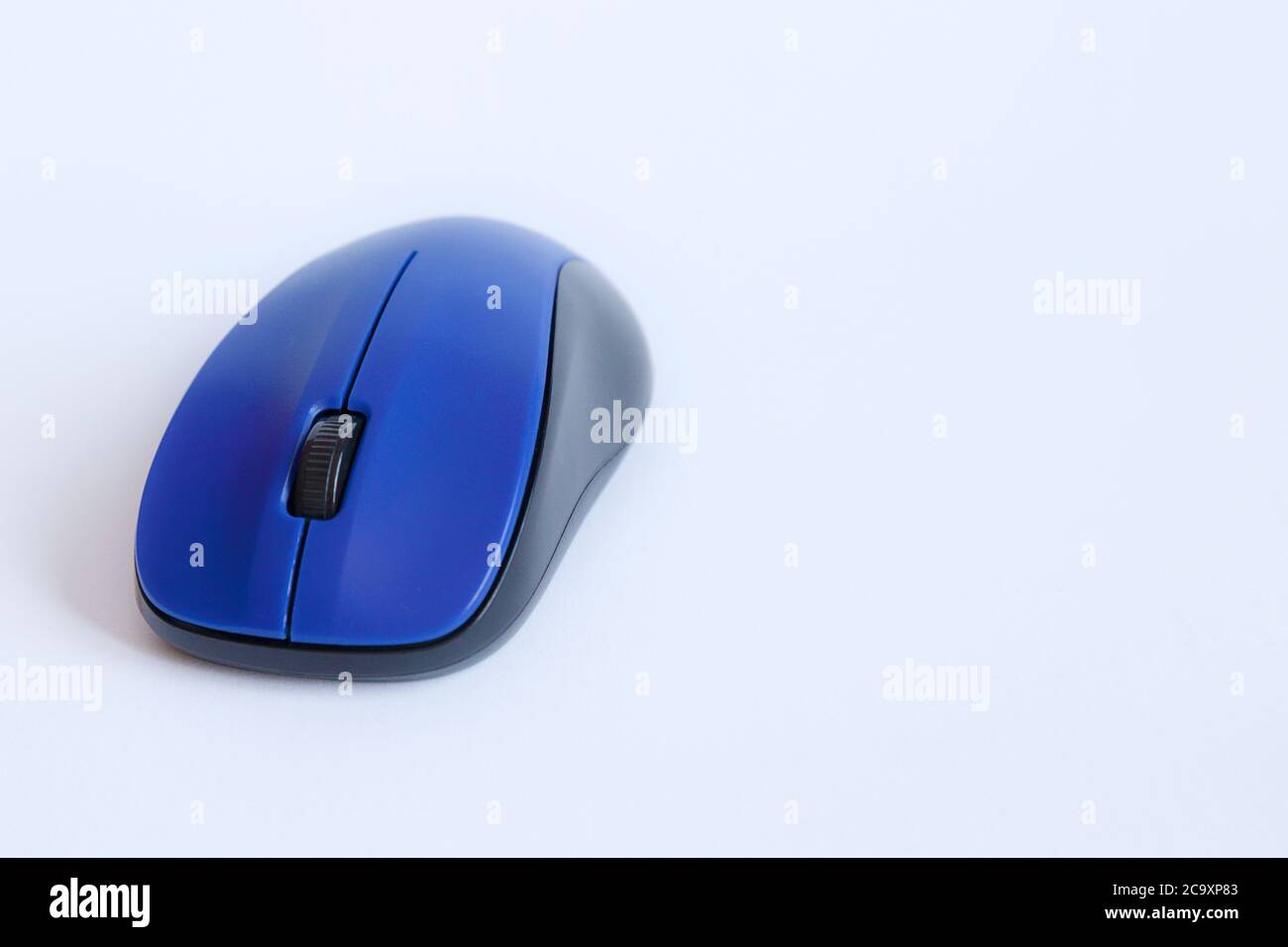 View of a blue wireless mouse on white background, with copy space ...