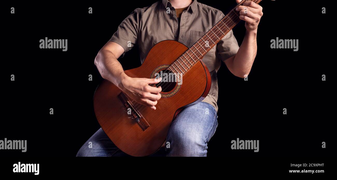 Classical guitarist plays piece of music. Men musician plays classical ...