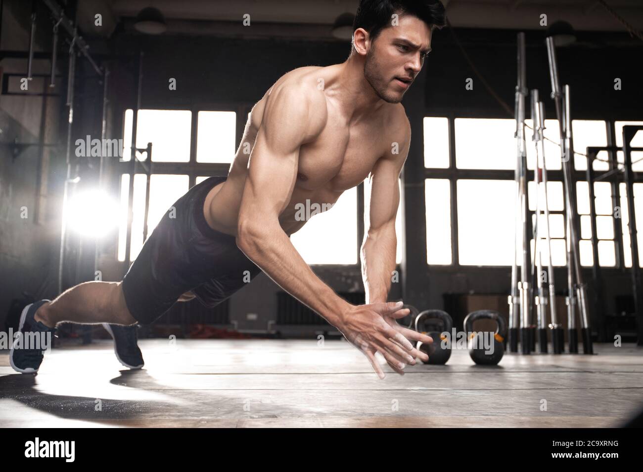 A muscular man doing a pushups at the crossfit gym Stock Photo - Alamy