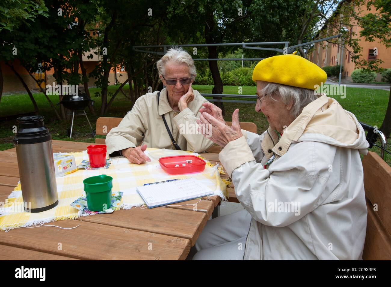 Older ladies play a board game out in the garden Stock Photo - Alamy