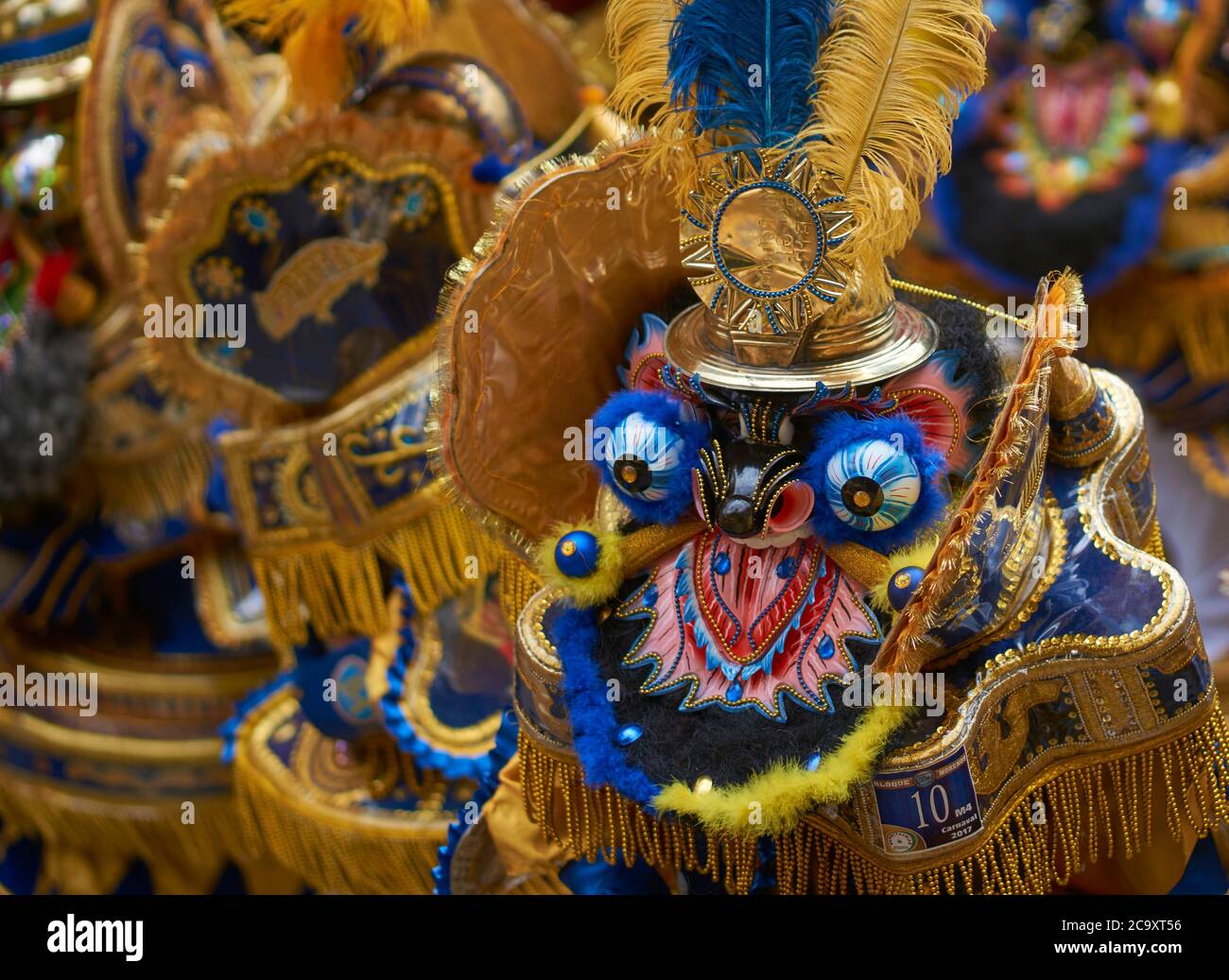 Masked morenada dancers in ornate costumes parade through the mining ...