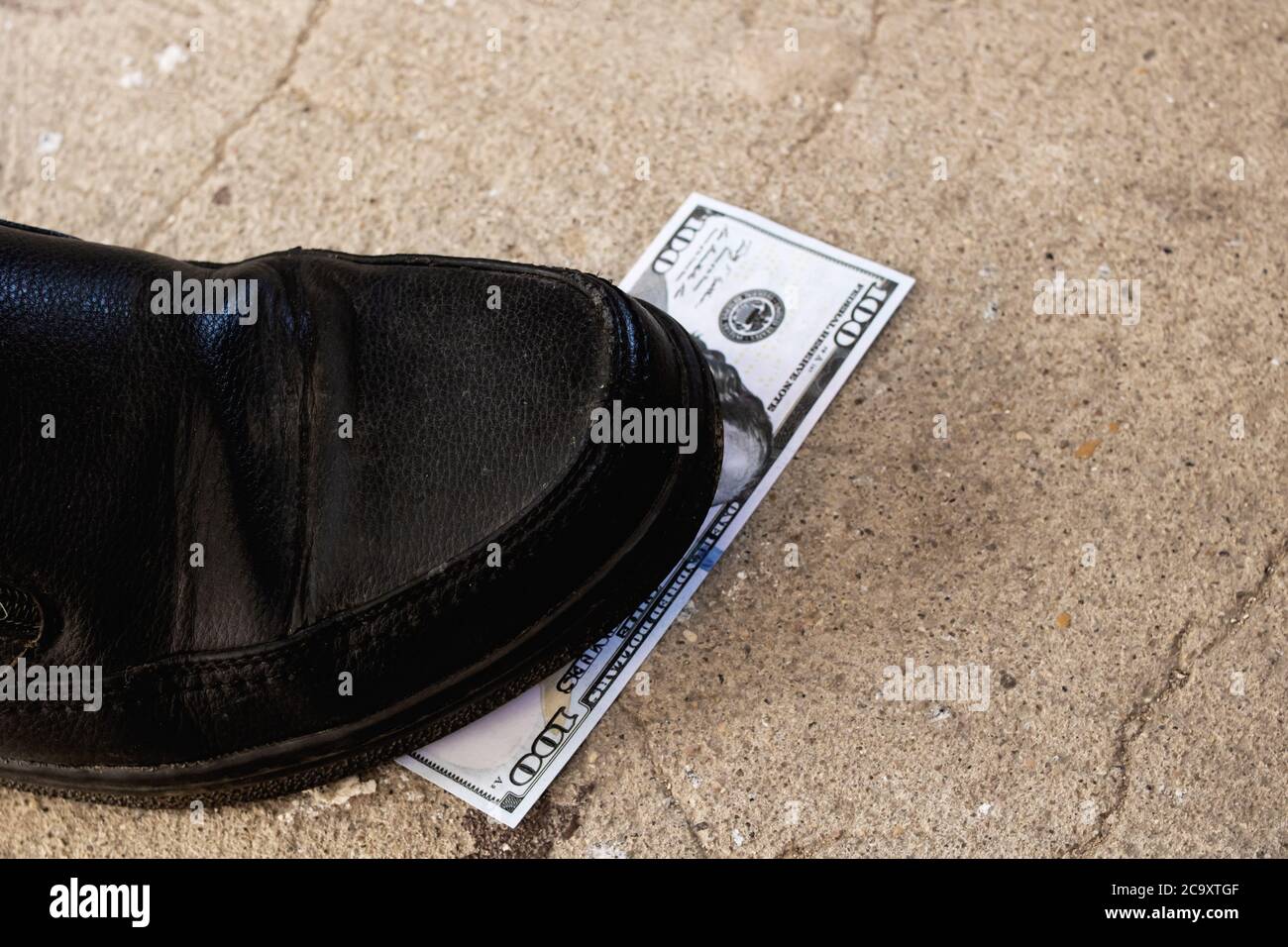 One hundred dollar bill under the shoe close up Stock Photo - Alamy