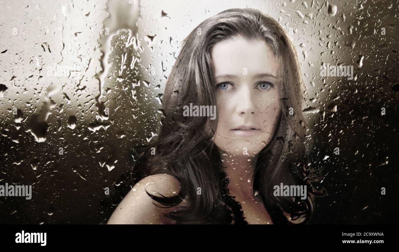 Woman looking through window rain hi-res stock photography and images ...