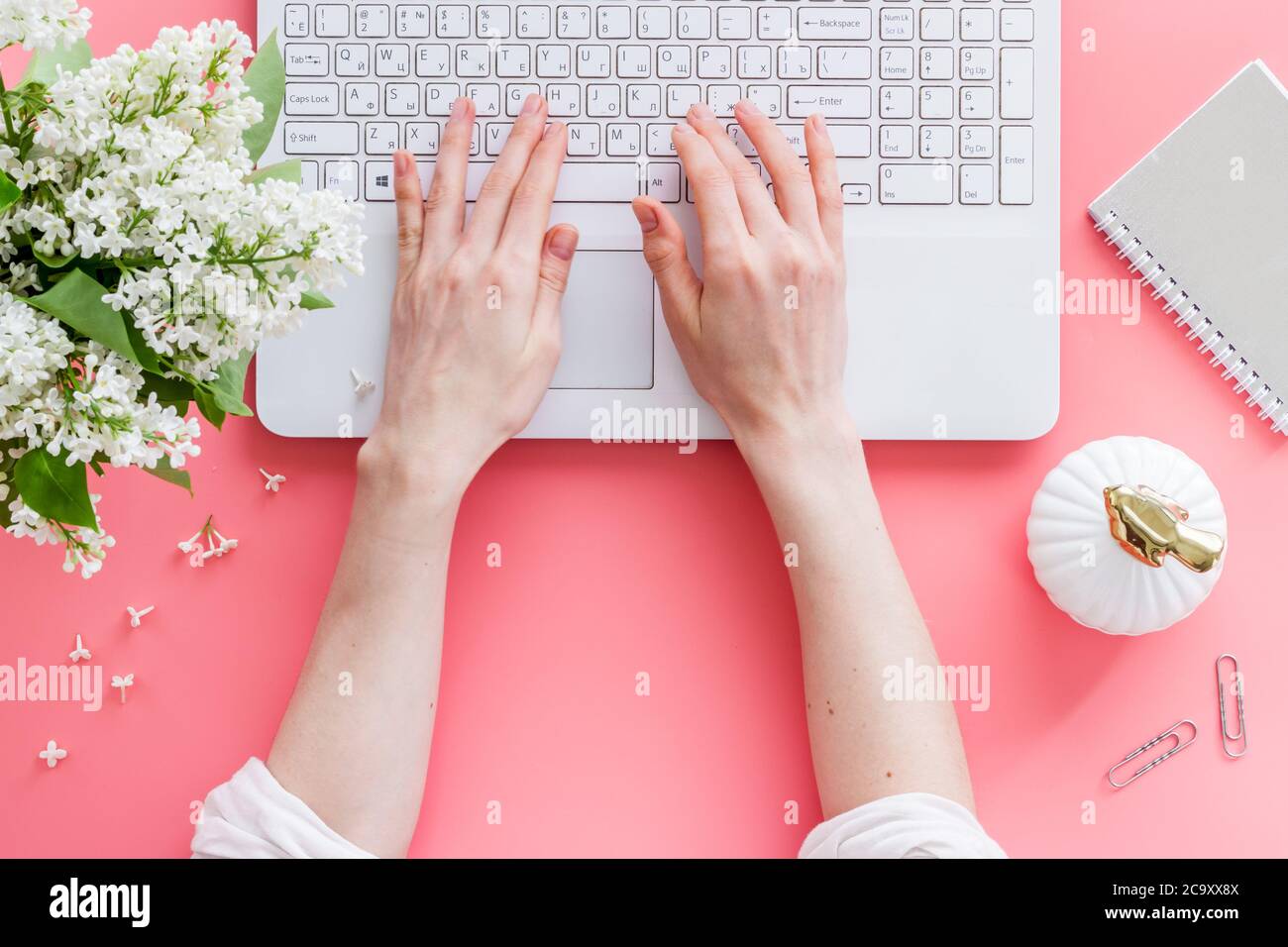 Girl typing on computer keyboard bright office space with flowers ...