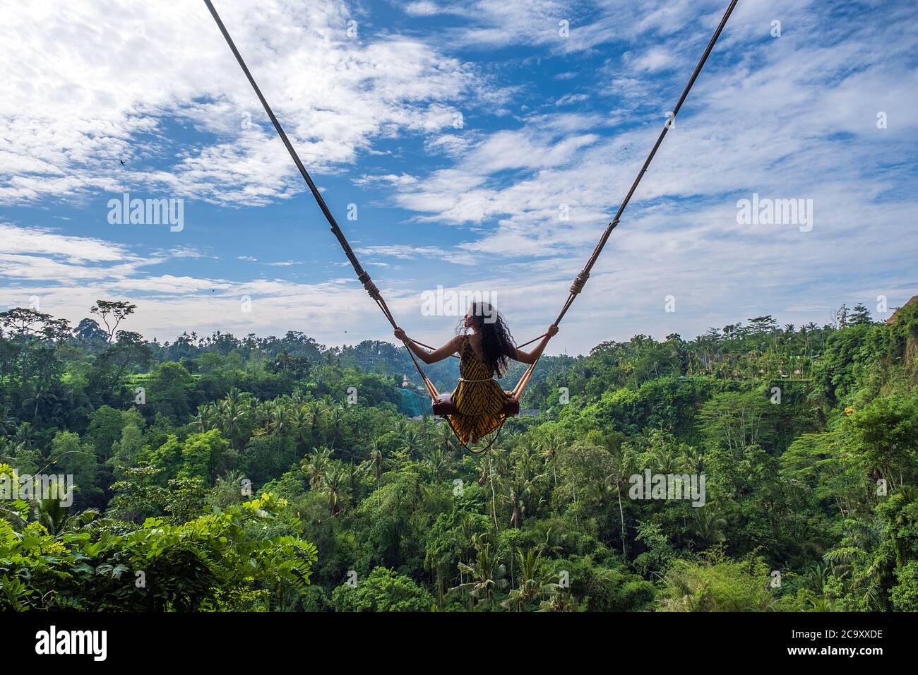 Wide angle shots of Bali Swing with female on it wearing red saree and ...