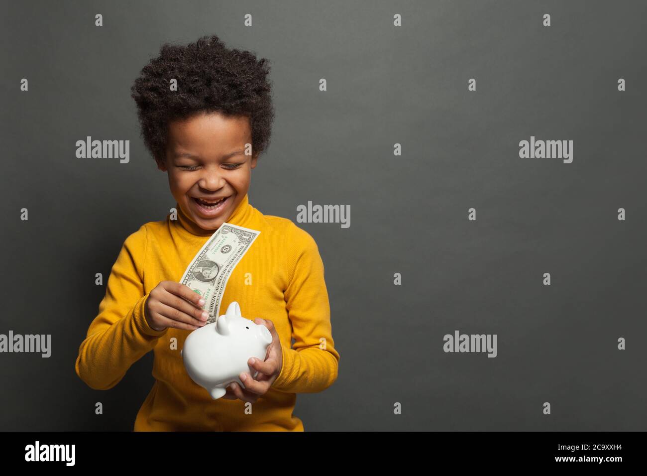 Happy successful African American child with money box and one us ...