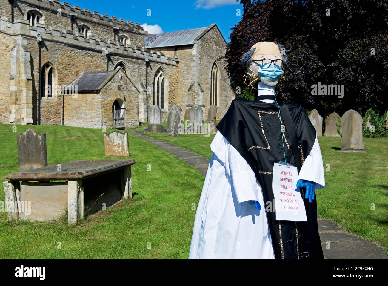 Scarecrow vicar in the churchyard of All Saints Church in the village ...