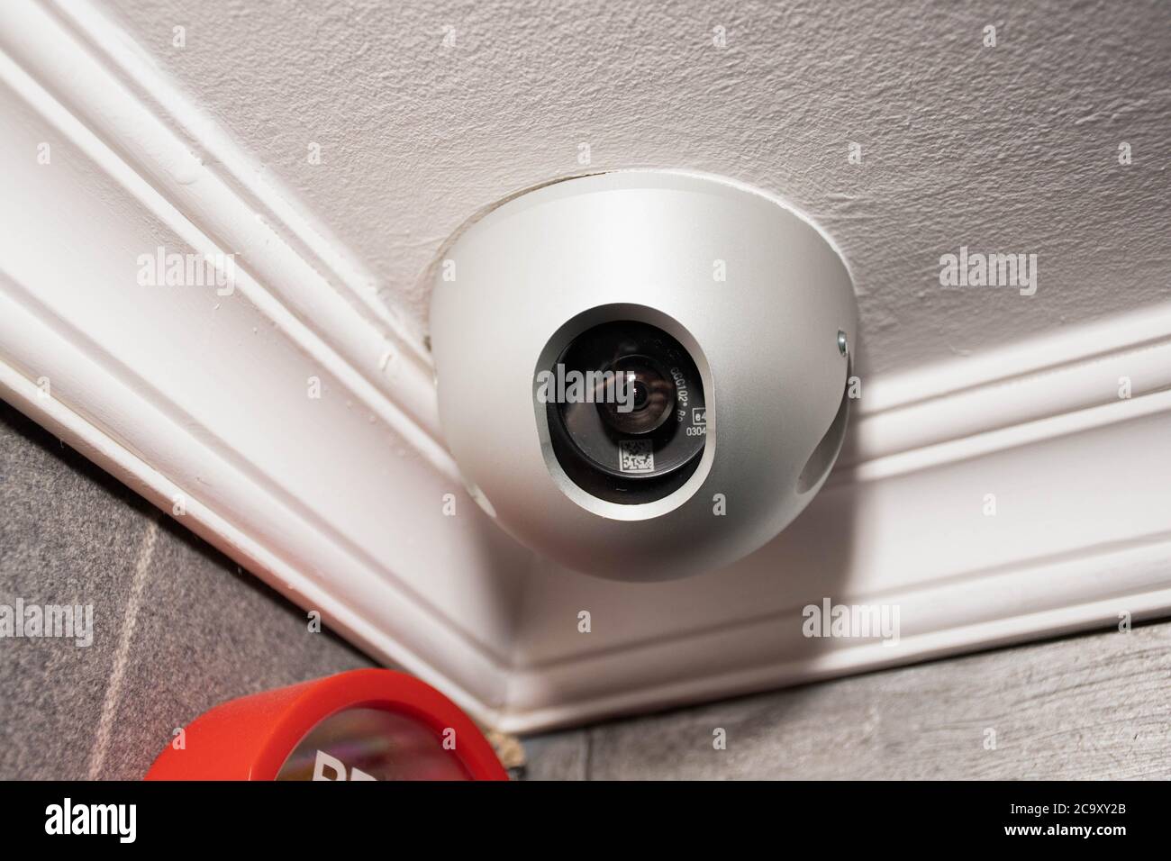 A security camera in the top corner of a door Stock Photo - Alamy