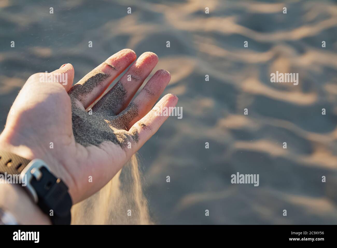 Sand is falling from girl's palm Stock Photo - Alamy