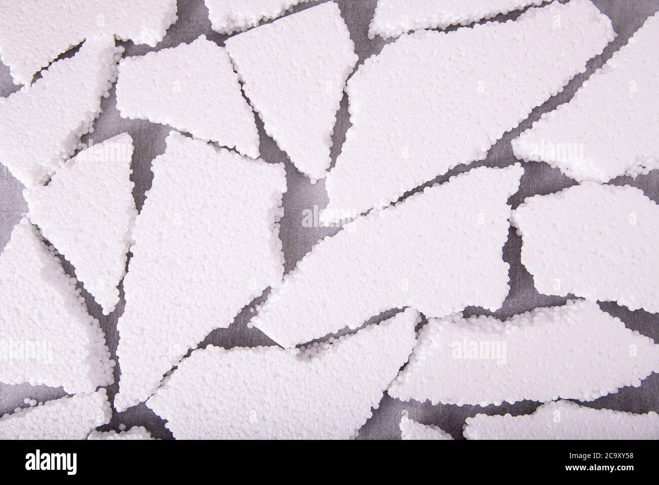 Pieces of white expanded polystyrene close-up on a gray background ...