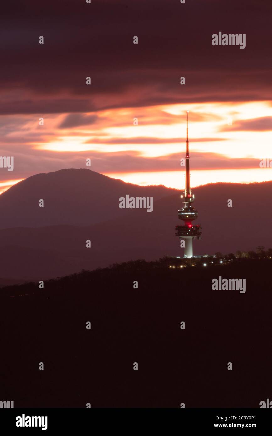 Tower in Canberra, Australia during sunset with layers of clouds and ...