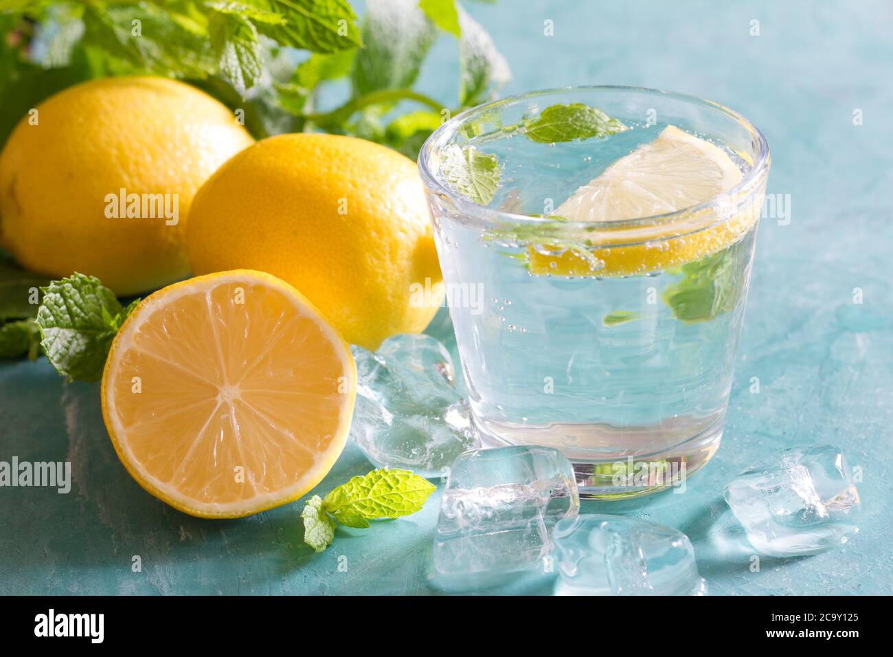 Refreshing water with lemon, mint and ice for summer heat background ...
