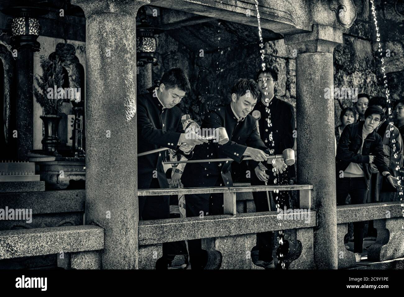 Scholars drinking from the Otowa-no-Taki waterfall holy water fountain ...