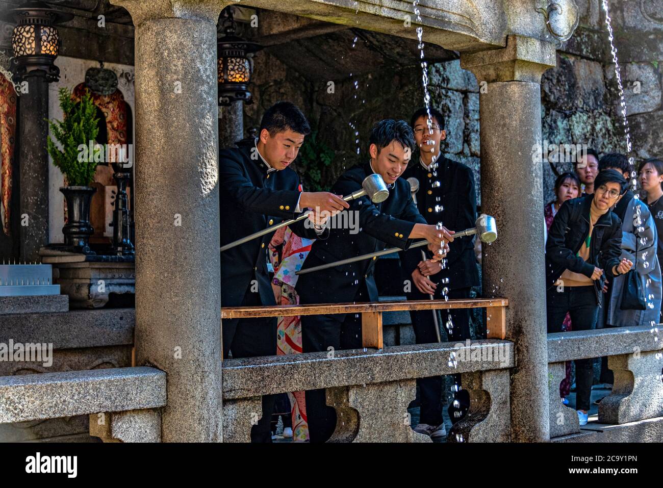 Scholars drinking from the Otowa-no-Taki waterfall holy water fountain ...