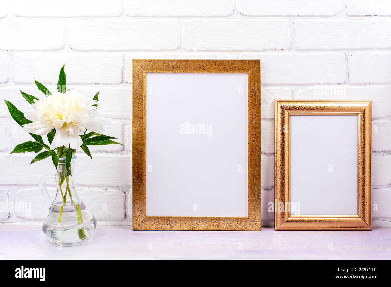 Two golden frames mockup with white peony in the glass pitcher vase ...