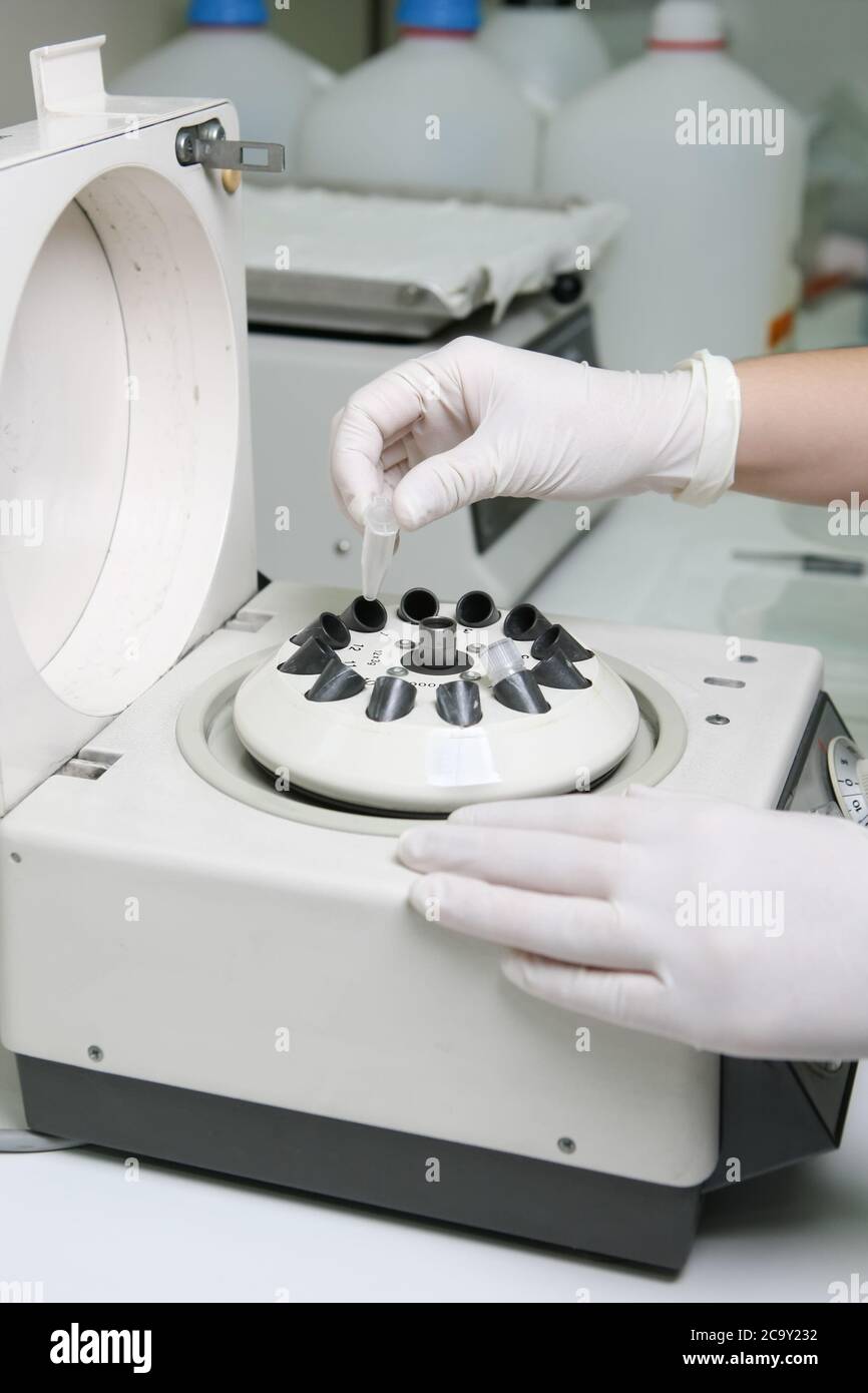 Scientists hands placing a sample in a centrifuge in a laboratory Stock ...