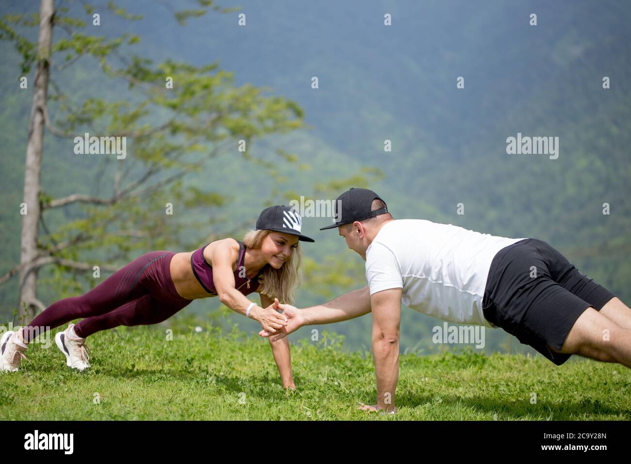 Young couple is working out on fresh air with beautiful outdoor ...