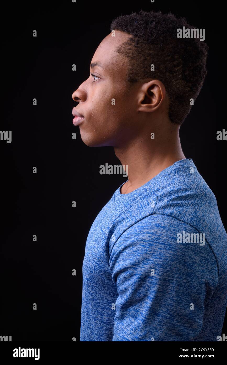 Young handsome African man against black background Stock Photo - Alamy