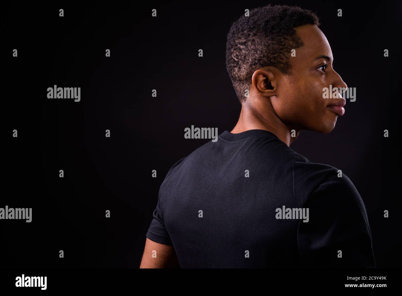 Young handsome African man against black background Stock Photo - Alamy