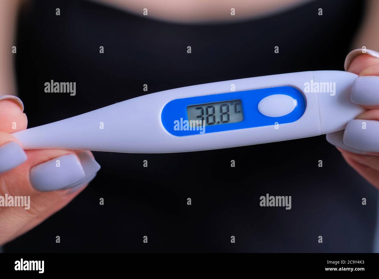 Woman hands showing digital medical thermometer with high temperature ...