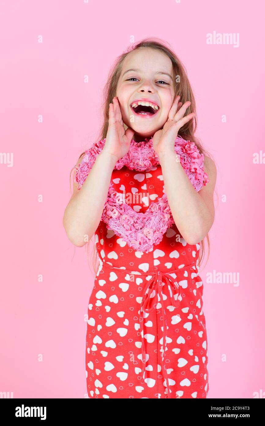 Romantic love concept. Happy girl holding rosy heart on pink background ...