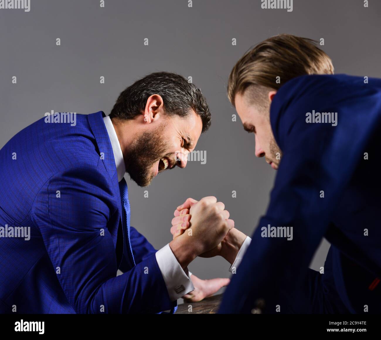 Men in suit or businessmen with aggressive faces compete in ...