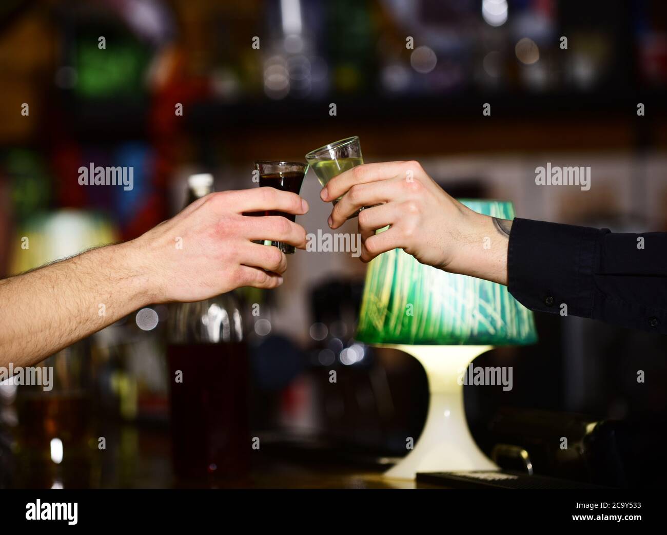 Male hands cheer with alcohol on blurred bar background. Alcohol ...