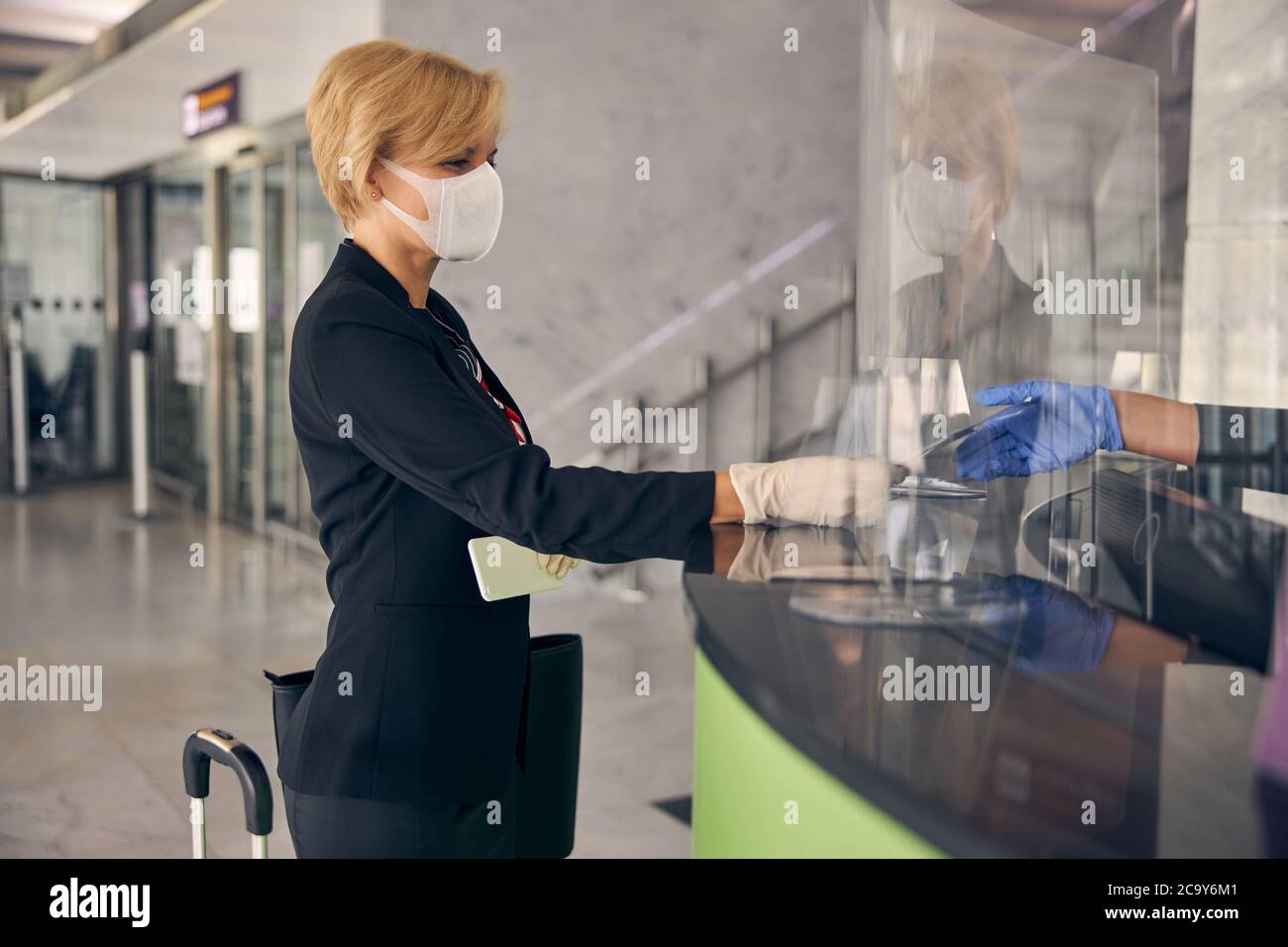 Charming businesswoman showing ticket at check-in desk in airport Stock ...