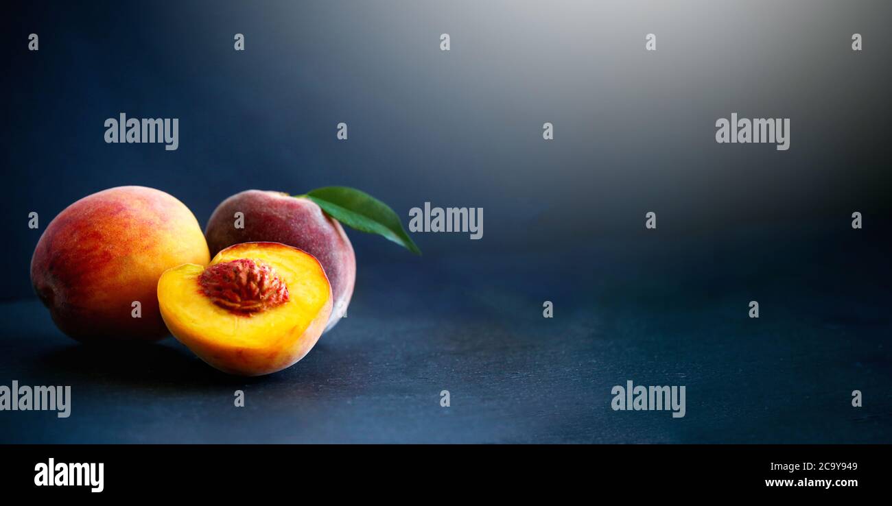 Fresh peaches and split with leaves on black background Stock Photo - Alamy