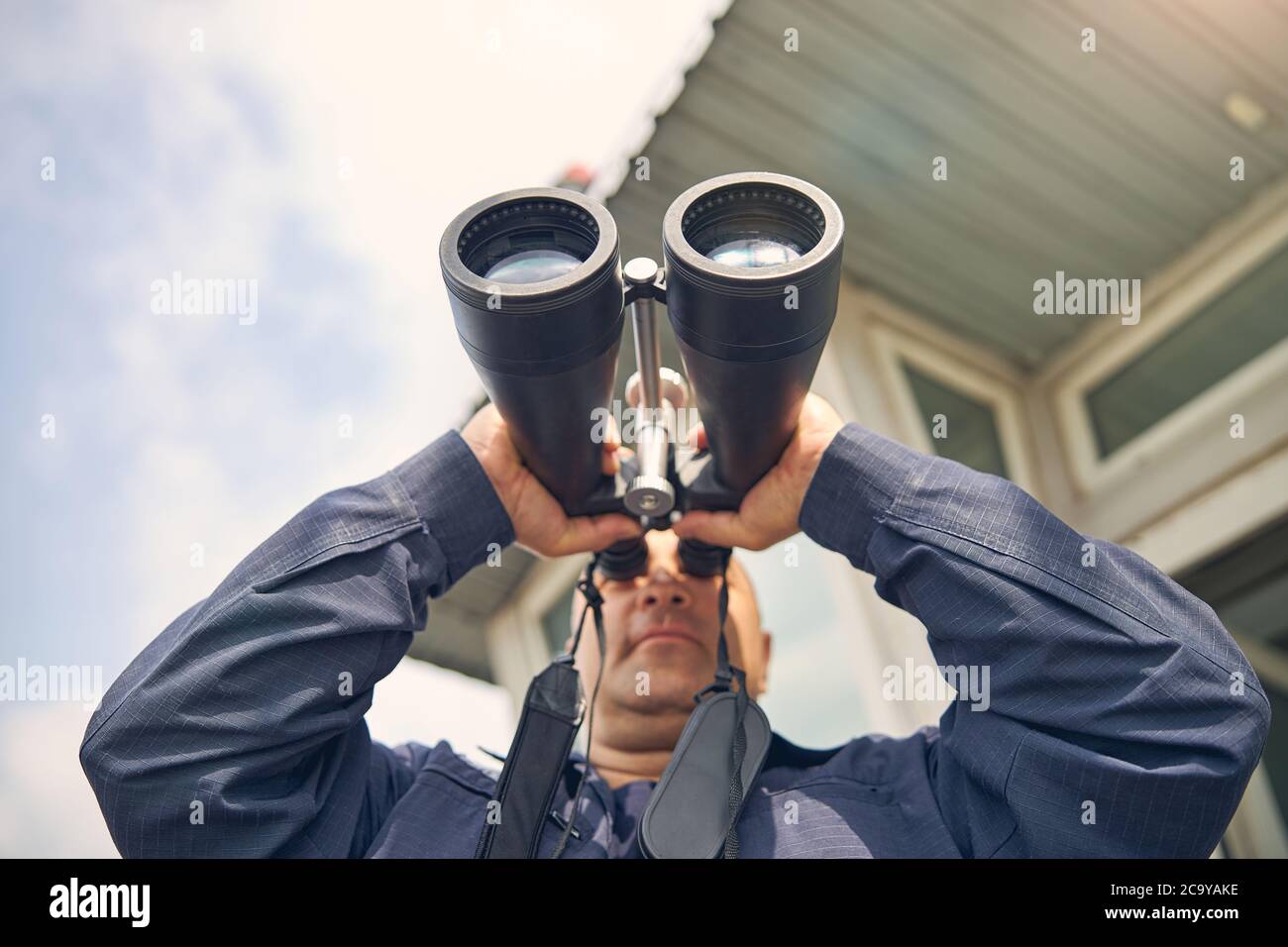Adult man using binoculars at the work Stock Photo - Alamy