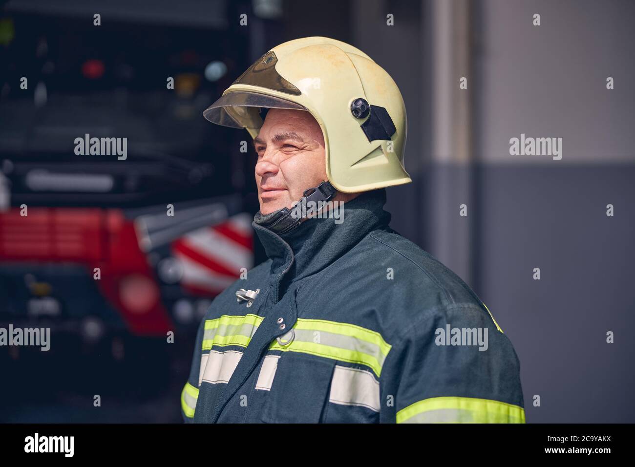 Rescue firefighter in safe green uniform standing at the outdoors Stock ...