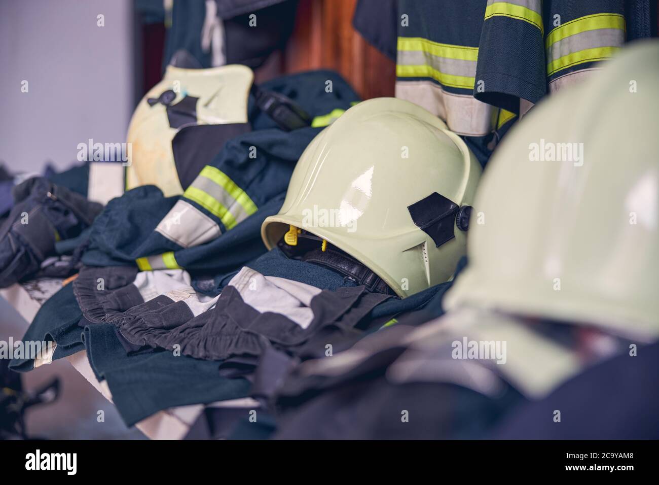 Firefighter suits and helmets hanging at fire station Stock Photo - Alamy