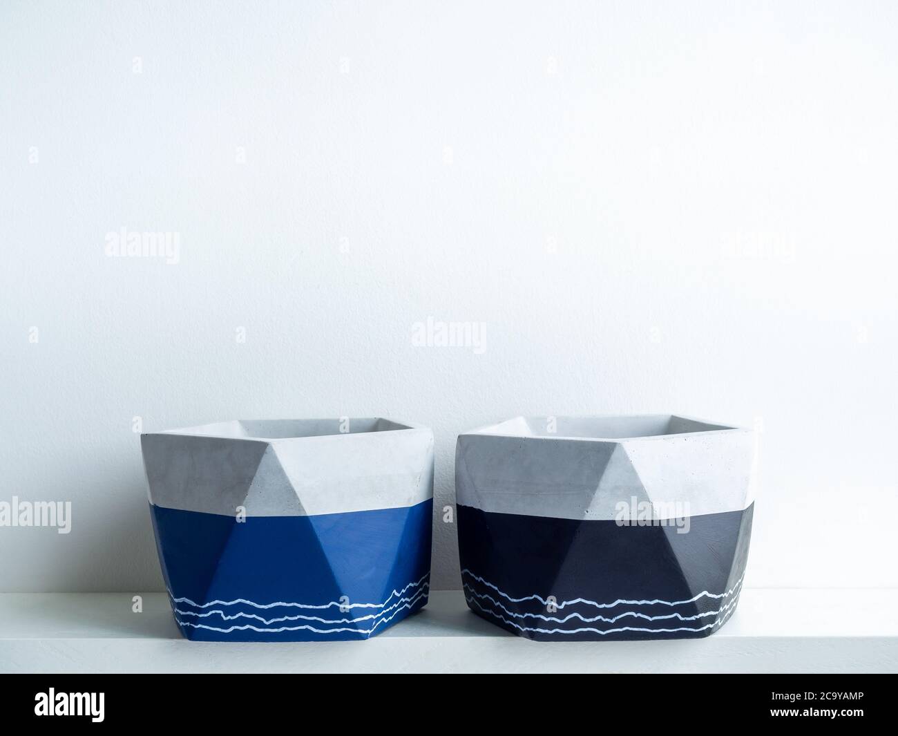 Empty modern geometric concrete planters on white shelf isolated on ...