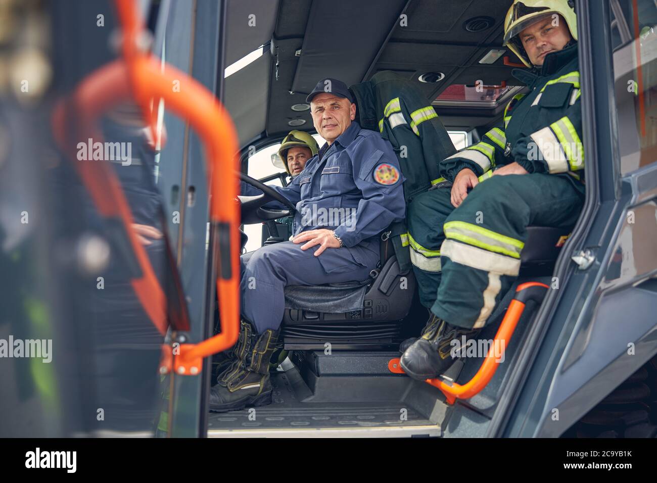 Group of adult people sitting in the fire machine Stock Photo - Alamy